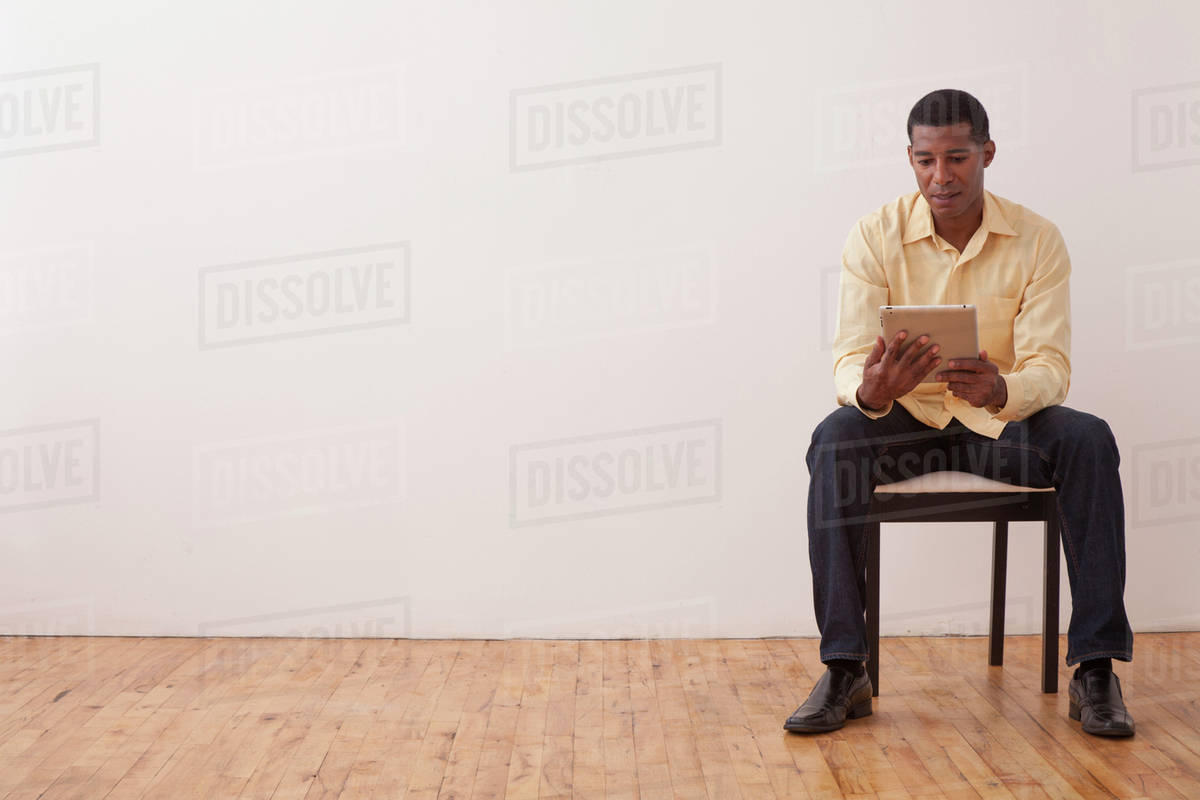 Black man using digital tablet - Royalty-free Stock Photo | Dissolve