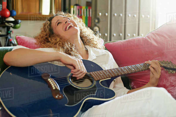 Caucasian woman playing guitar - Royalty-free Stock Photo | Dissolve