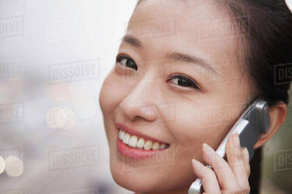 Chinese woman talking on cell phone - Stock Photo - Dissolve