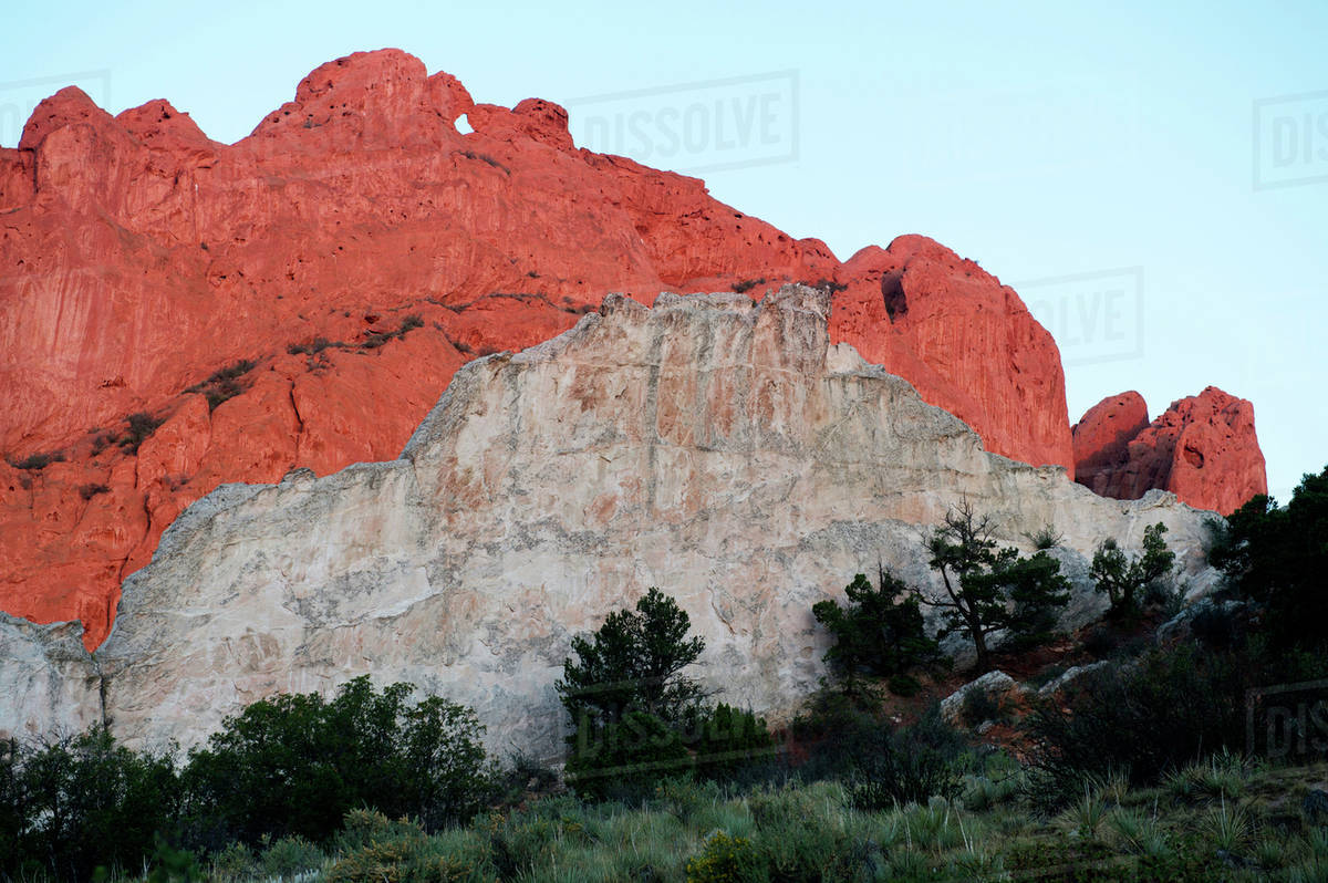 Red cliffs rising in rural landscape - Stock Photo - Dissolve