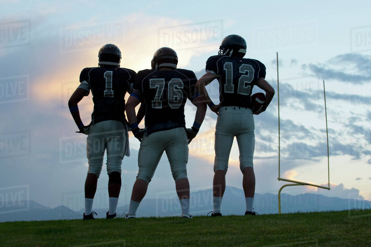 Football players standing on field - Royalty-free Stock Photo | Dissolve