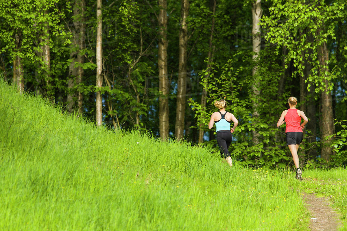 Caucasian women running on path - Royalty-free Stock Photo | Dissolve