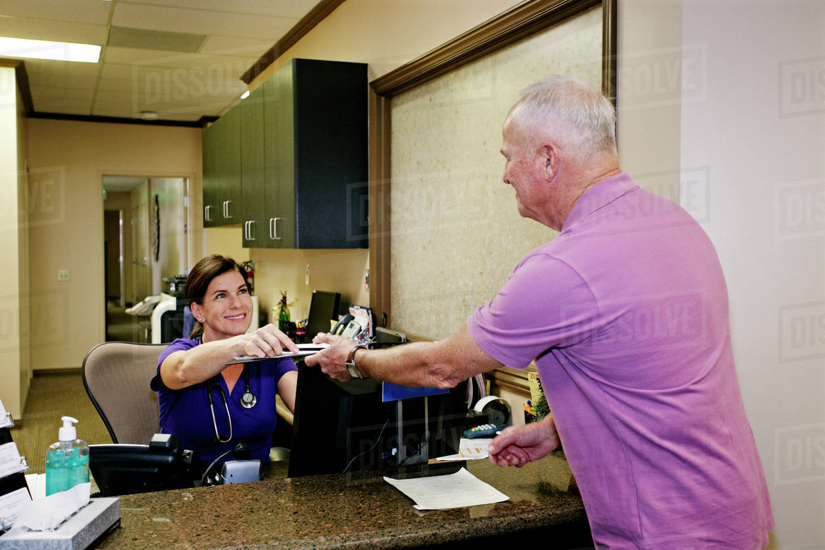 Caucasian nurse handing clipboard to patient - Royalty-free Stock Photo ...