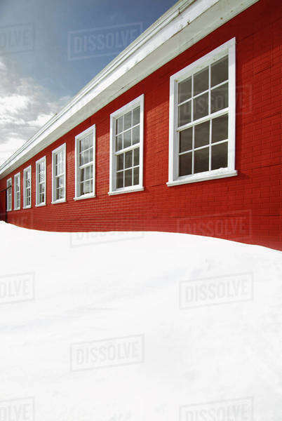 Snow piled up outside red building - Stock Photo - Dissolve