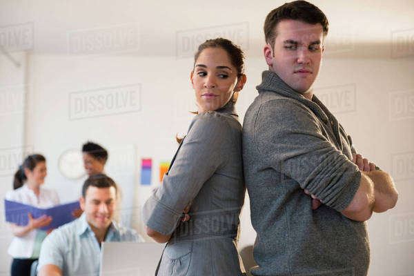 Business people standing back to back in office - Royalty-free Stock ...