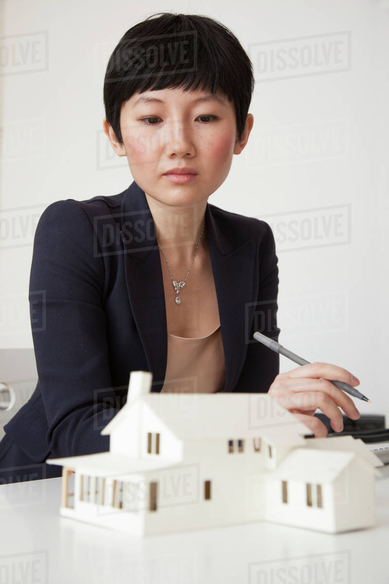 Businesswoman working on model in office - Stock Photo - Dissolve