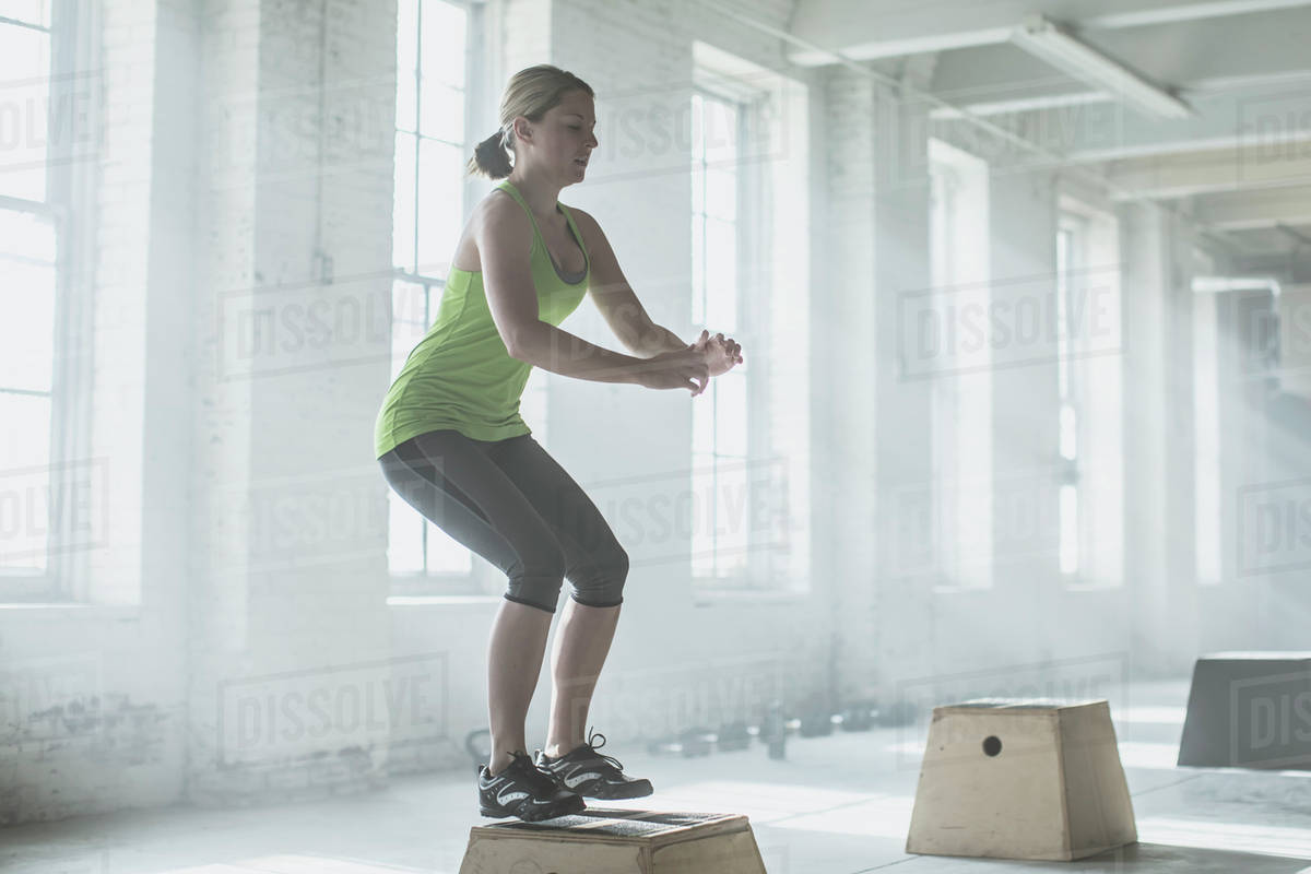 Athlete jumping on platform in gym - Royalty-free Stock Photo | Dissolve