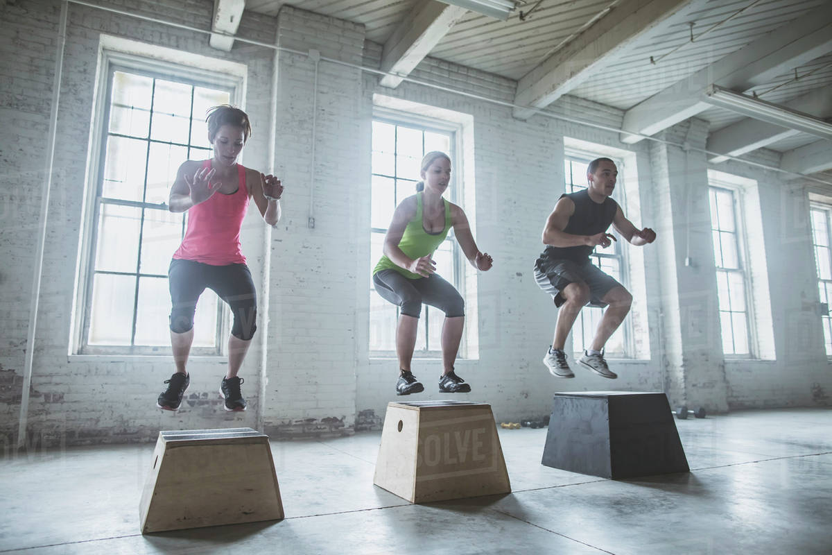 Athletes jumping on platforms in gym - Stock Photo - Dissolve