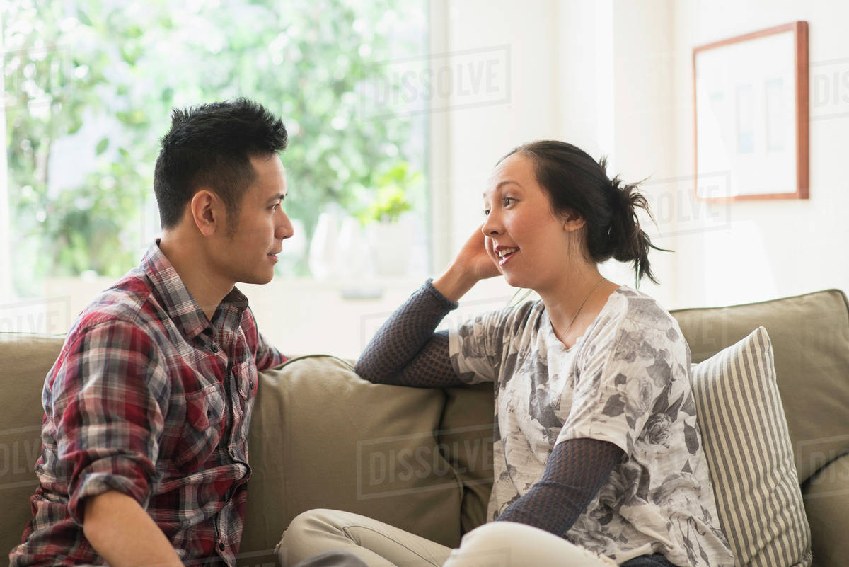 Couple talking on sofa in living room - Royalty-free Stock Photo | Dissolve