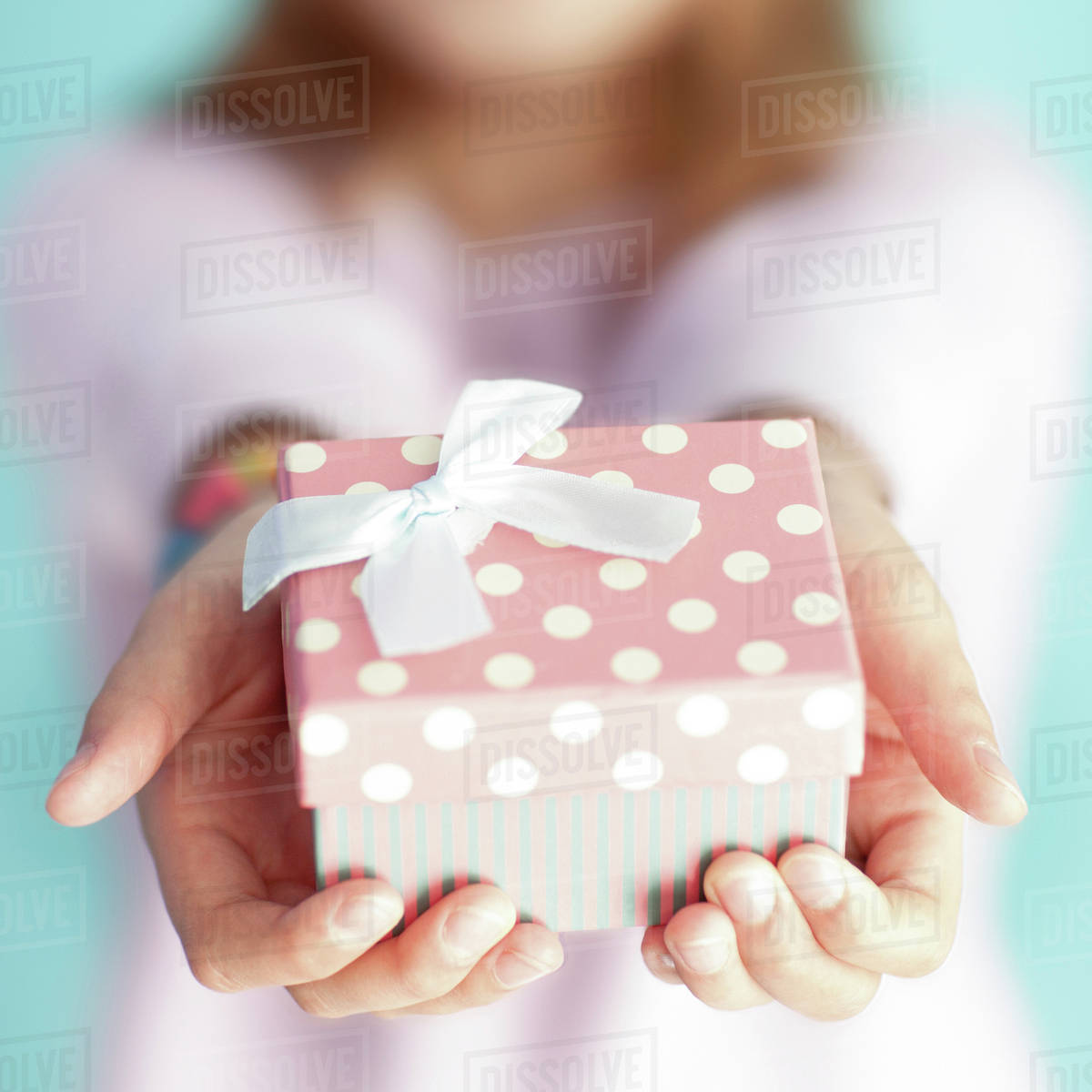 Close up of girl holding wrapped gift - Royalty-free Stock Photo | Dissolve