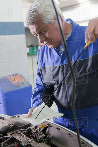 Older Hispanic mechanic repairing car in garage - Royalty-free Stock ...