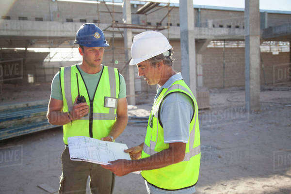 Caucasian construction workers talking at construction site - Stock ...
