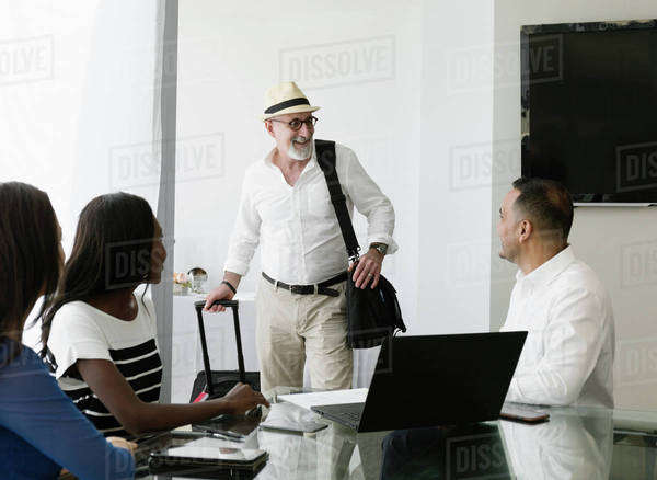 Businessman greeting colleagues in office meeting - Royalty-free Stock ...