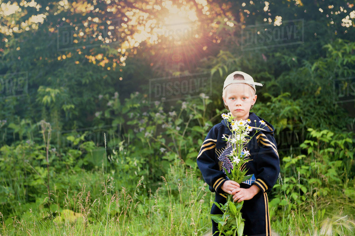 Caucasian boy picking flowers in rural field - Royalty-free Stock Photo ...