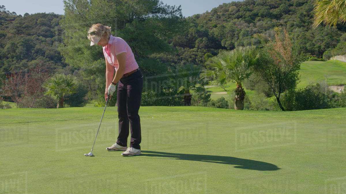 Caucasian woman putting on golf course - Royalty-free Stock Photo ...