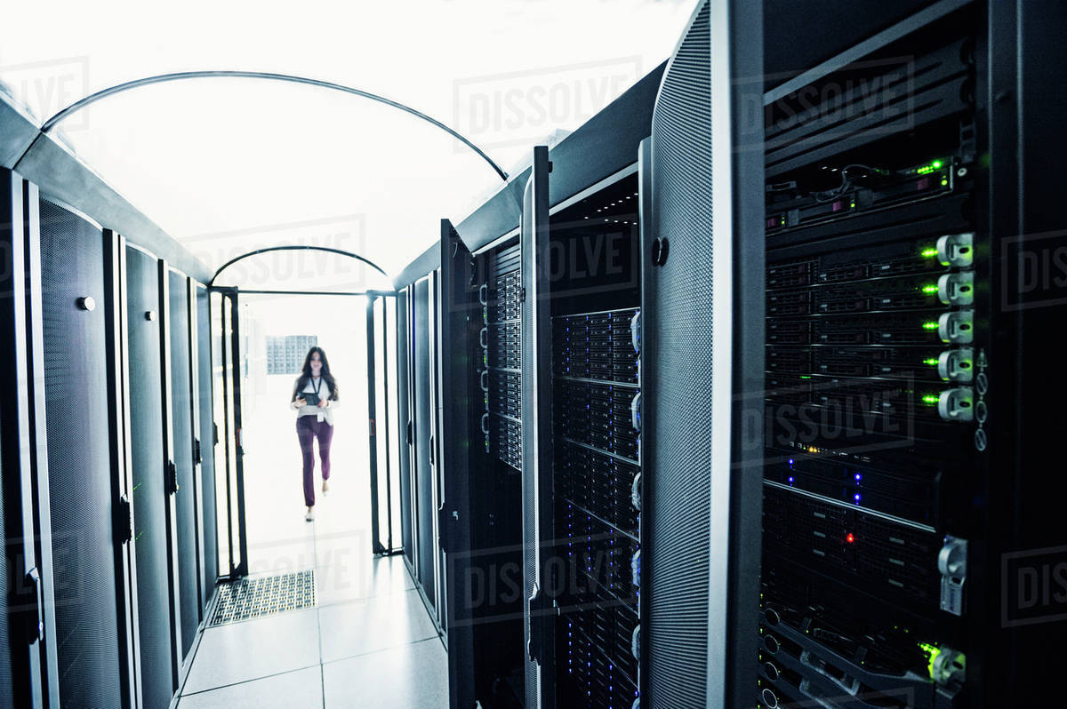 Technician walking in server room - Stock Photo - Dissolve