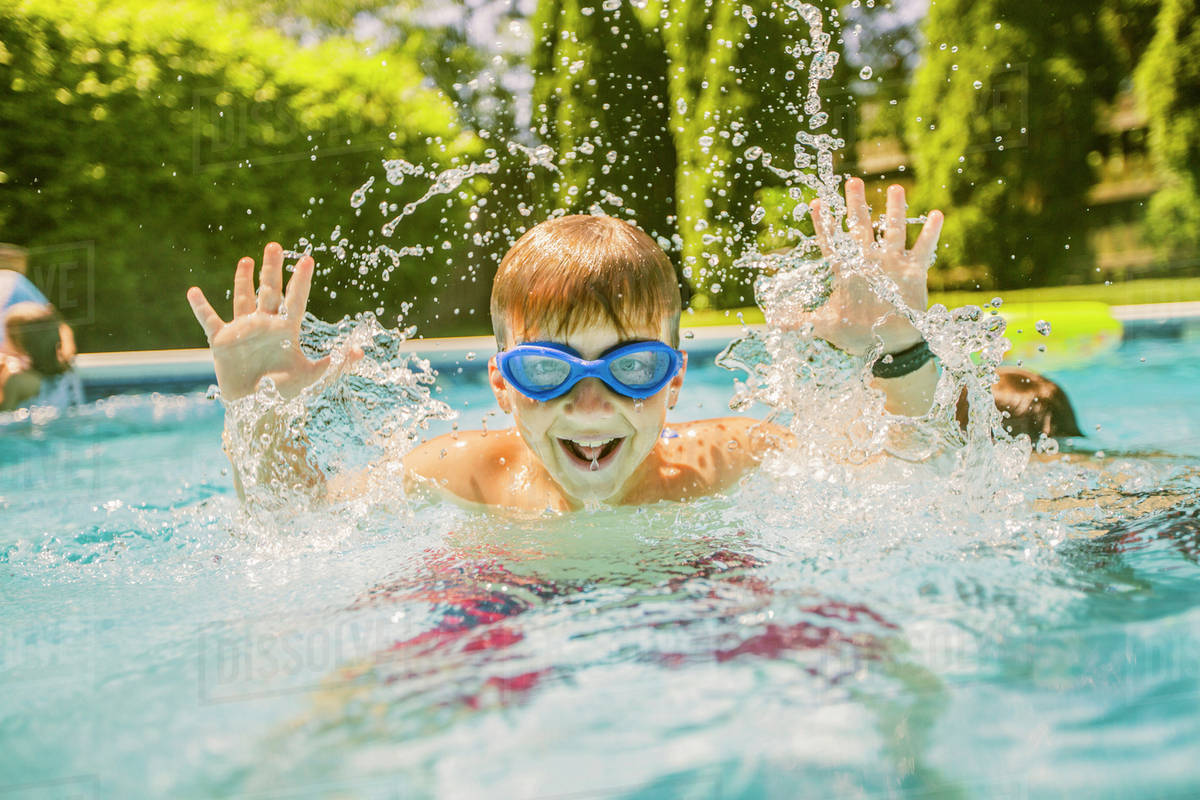 Boy splashing in swimming pool - Royalty-free Stock Photo | Dissolve