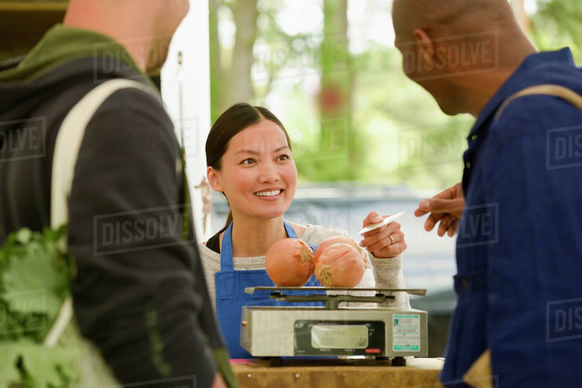 Clerk helping customers at farmers market - Royalty-free Stock Photo ...