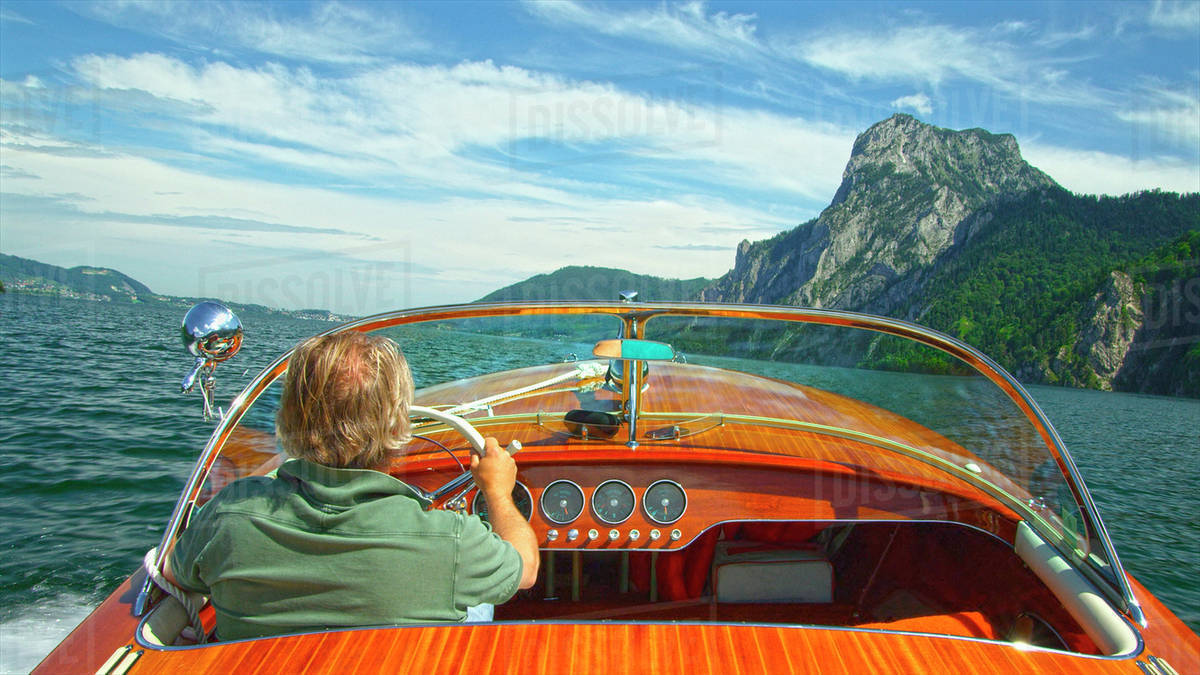 Caucasian man driving speedboat on remote lake - Royalty-free Stock ...