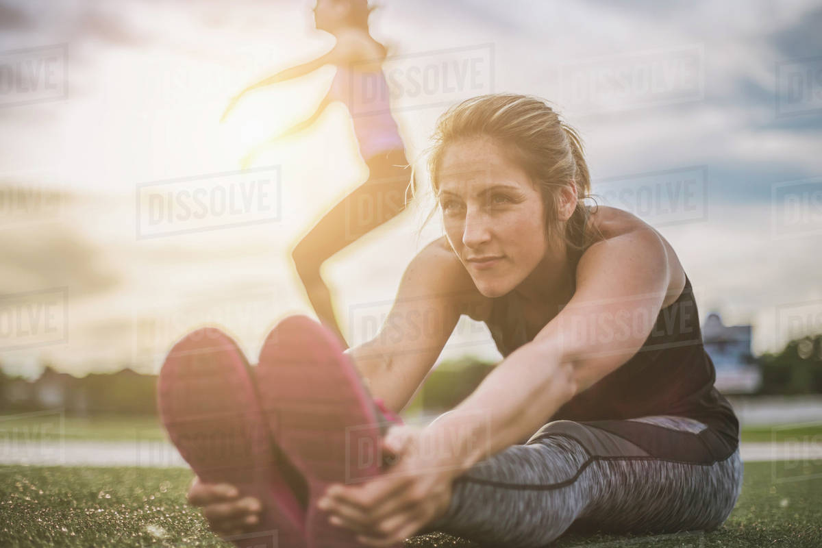 Athletes stretching on sports field - Royalty-free Stock Photo | Dissolve