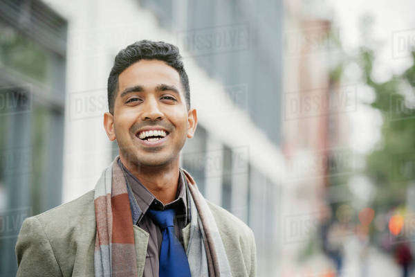 Indian man smiling in city - Stock Photo - Dissolve