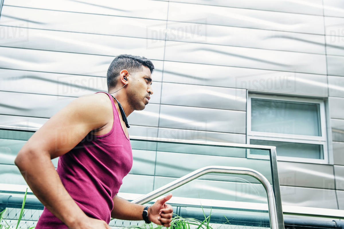 Indian man jogging on city steps - Royalty-free Stock Photo | Dissolve