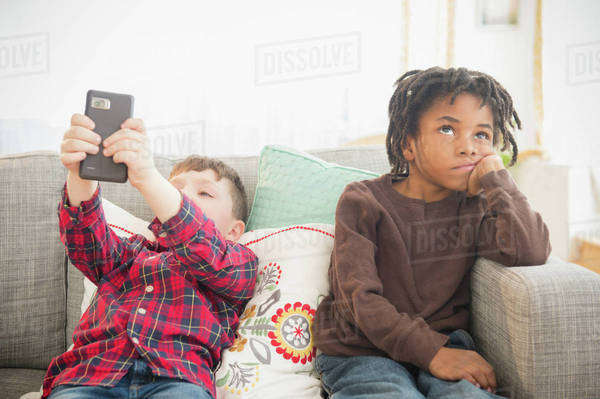 Boy with cell phone ignoring friend - Stock Photo - Dissolve