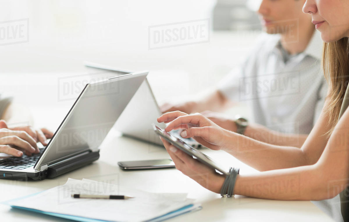 Business people using technology in office meeting - Stock Photo - Dissolve