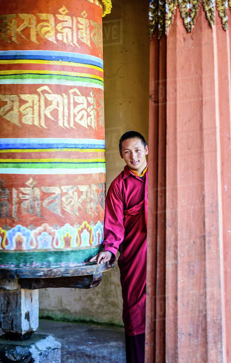 Asian monks standing by pillar in temple - Stock Photo - Dissolve