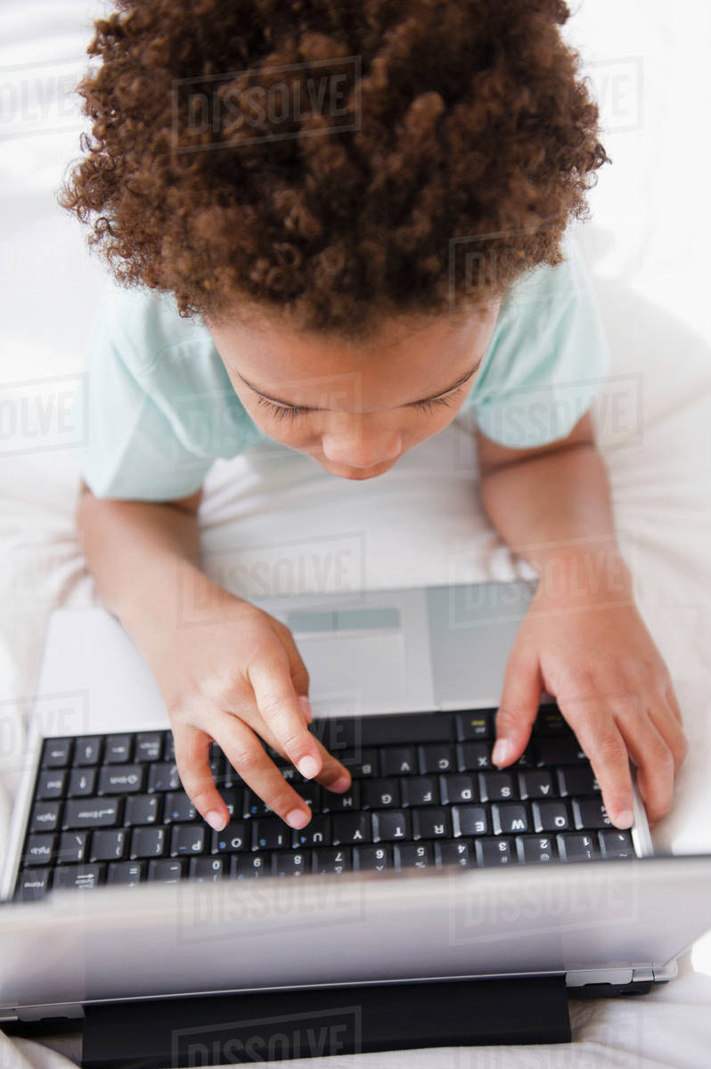 Black boy typing on computer - Royalty-free Stock Photo | Dissolve