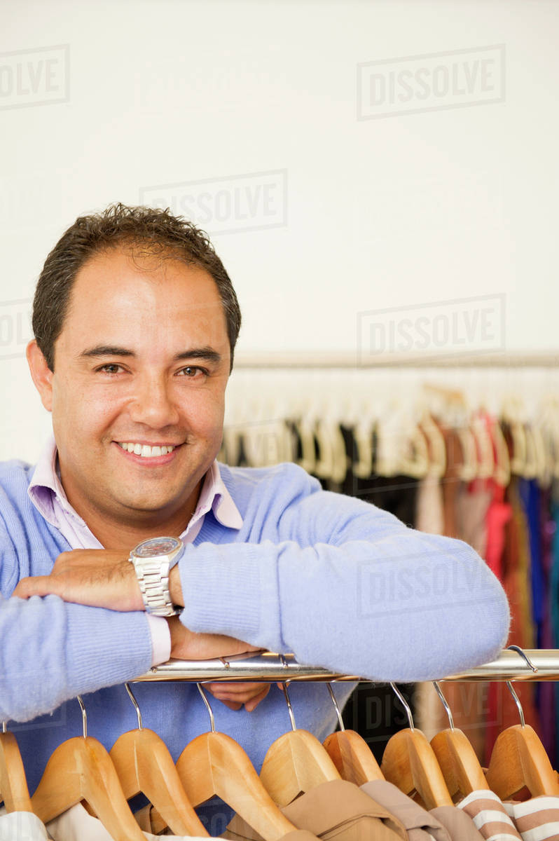Hispanic man working in clothing store - Stock Photo - Dissolve