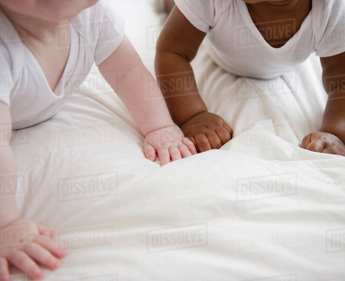 Babies laying on floor together - Royalty-free Stock Photo | Dissolve