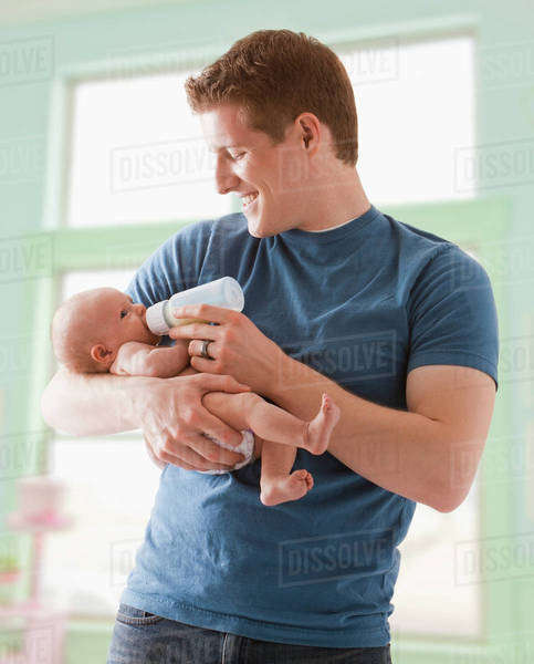 Caucasian father feeding baby girl - Royalty-free Stock Photo | Dissolve