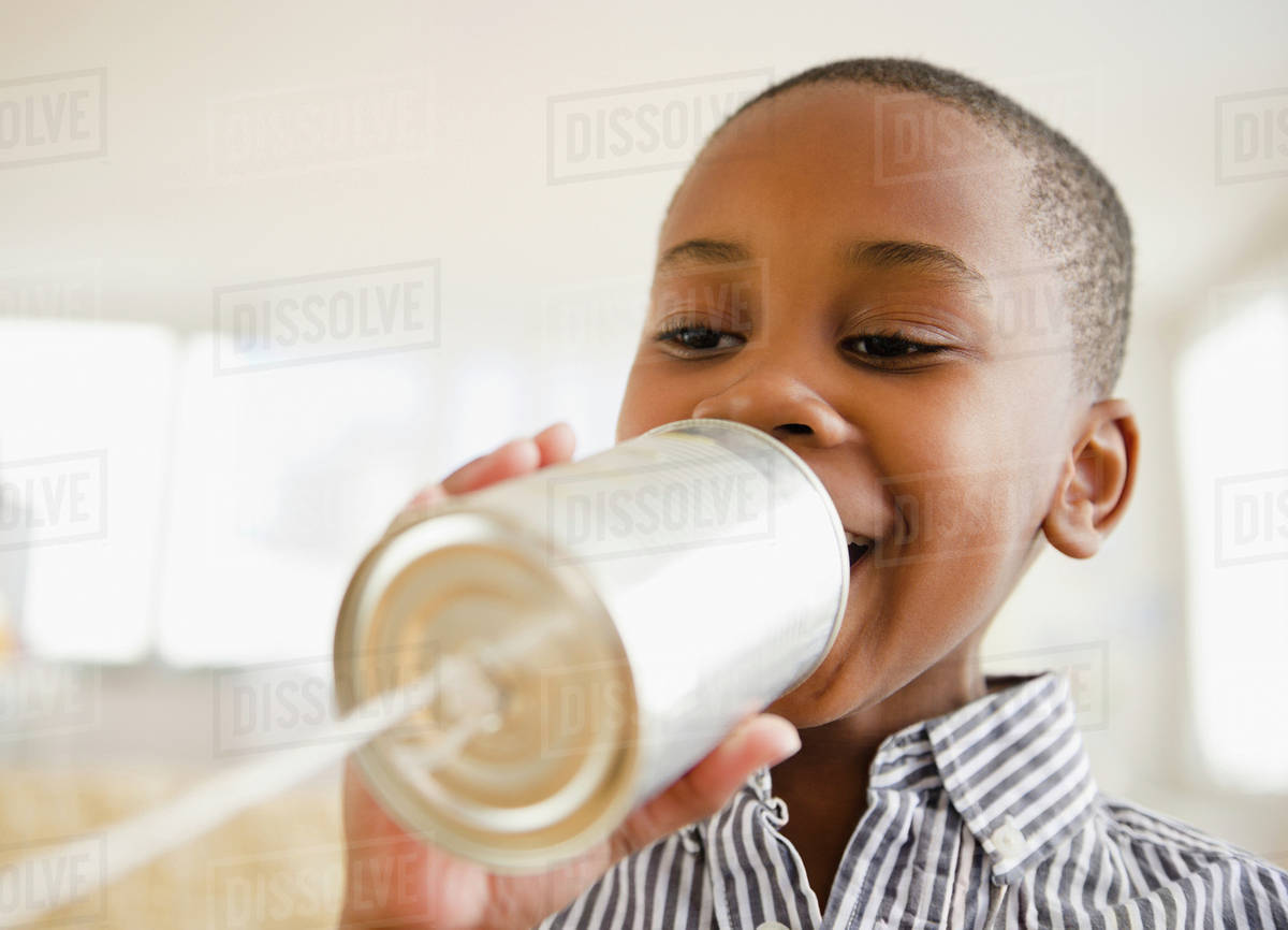Black boy talking into tin can phone - Stock Photo - Dissolve