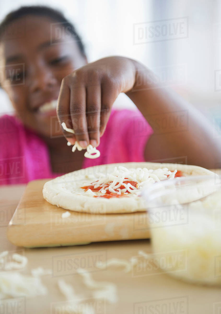 Black girl making pizza - Royalty-free Stock Photo | Dissolve