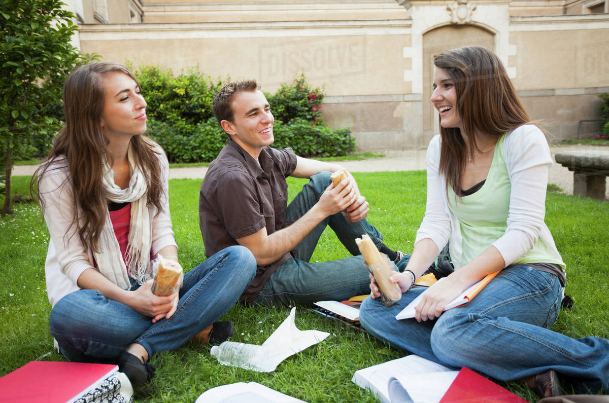 Caucasian friends eating lunch on grass - Royalty-free Stock Photo ...