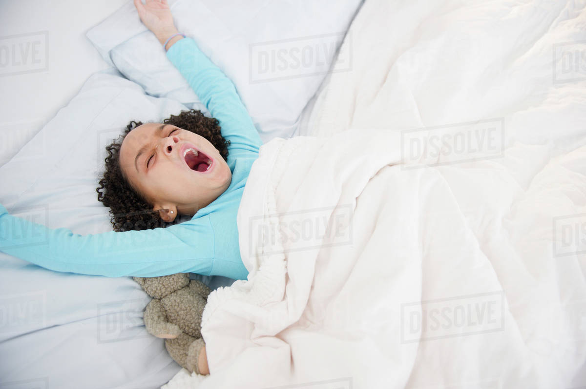 African American girl waking up in bed - Royalty-free Stock Photo ...