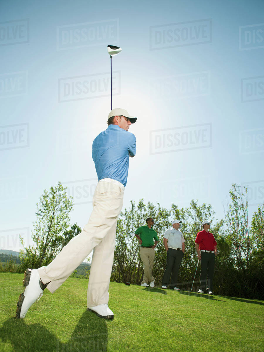 Men playing golf together on golf course - Stock Photo - Dissolve