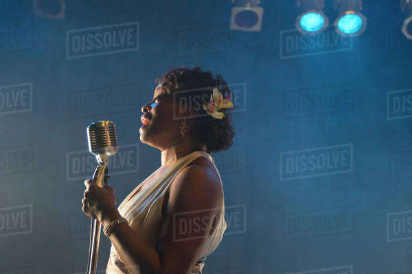 Black woman singing on stage - Royalty-free Stock Photo | Dissolve