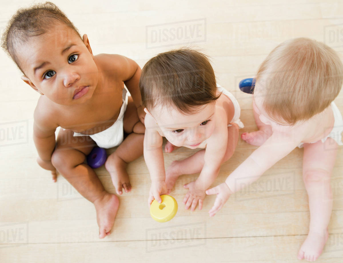 Babies playing together on floor - Royalty-free Stock Photo | Dissolve