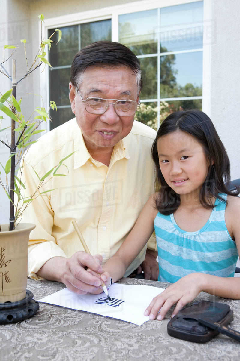 Chinese grandfather teaching granddaughter calligraphy - Royalty-free ...