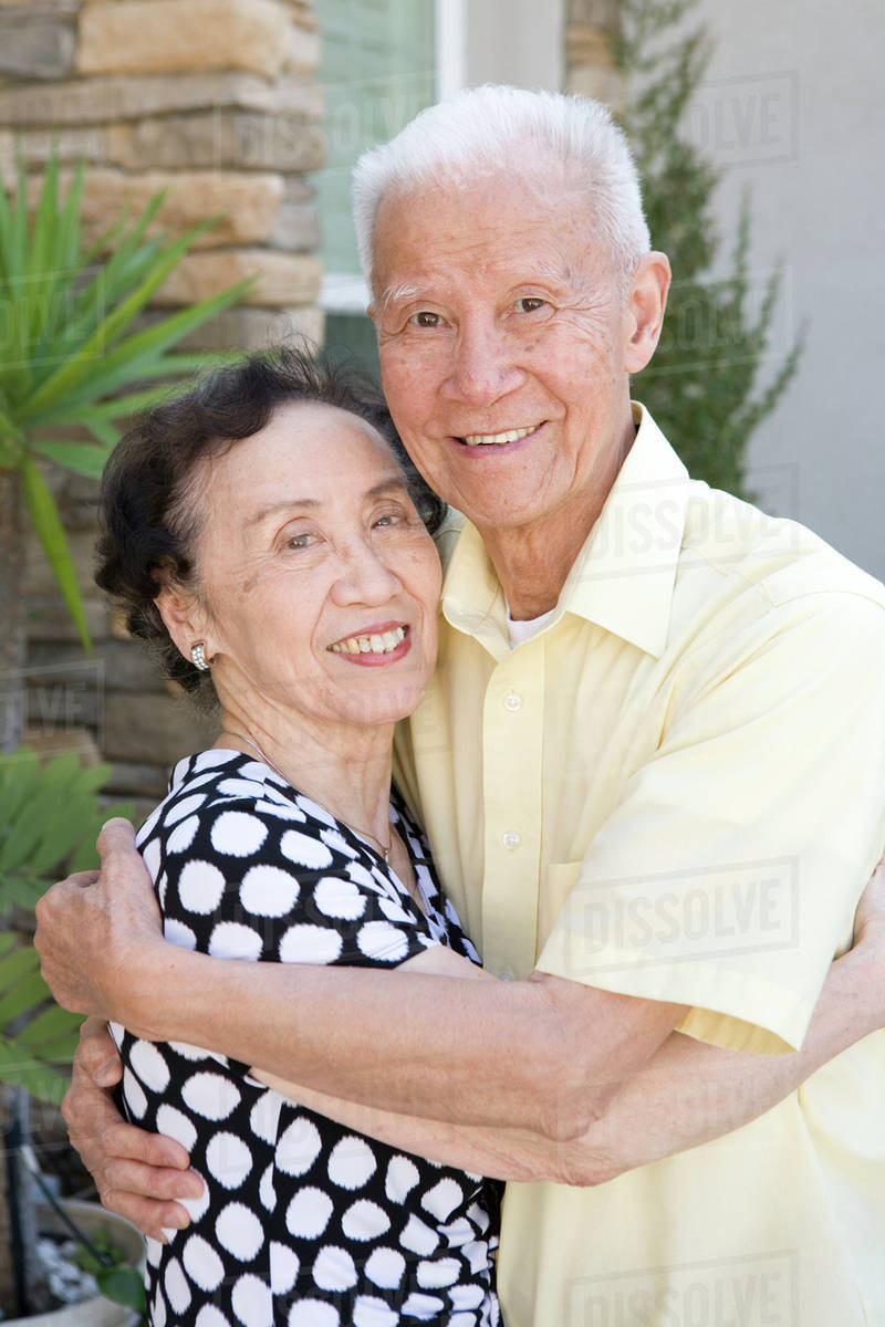 Senior Chinese couple hugging - Stock Photo - Dissolve