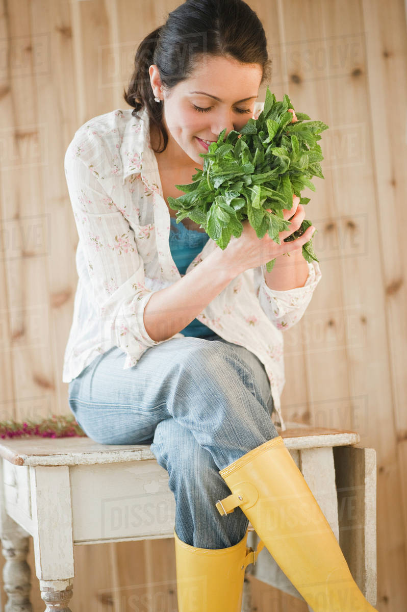 Brazilian woman smelling fresh mint - Royalty-free Stock Photo | Dissolve