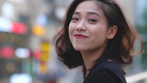 Close up of one Chinese girl turn back looking at camera smile in slow ...