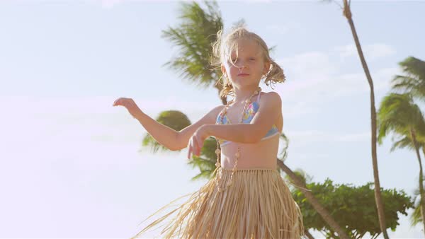 An adorable little girl shows off her hula dance moves for the camera ...