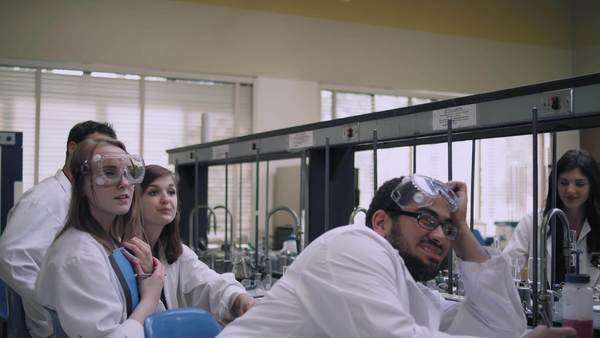 Students in a science lab listen to their professor and take notes - 4K ...