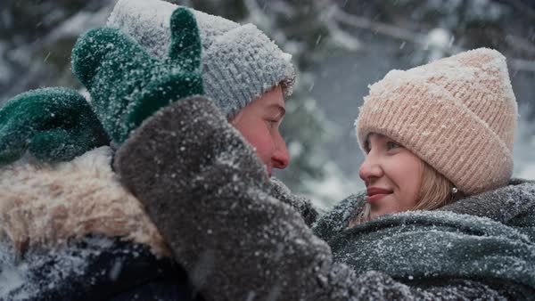 CLose-up of young couple hugging and kissing,smiling, whispering ...