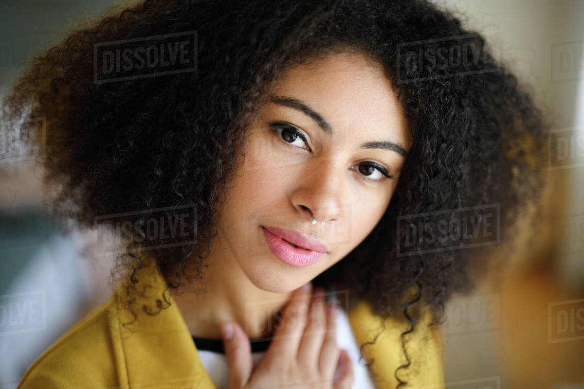 Close-up front view portrait of beautiful young woman indoors, looking ...