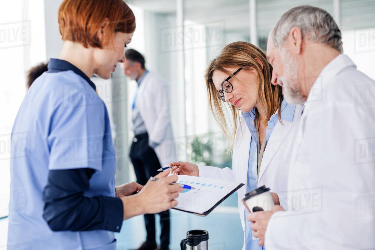 Group of doctors on conference, medical team standing and discussing ...