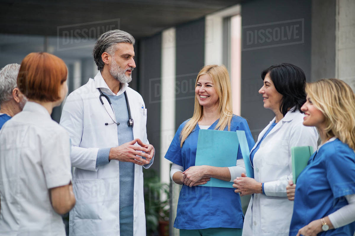 A group of doctors standing in hospital corridor on medical conference ...